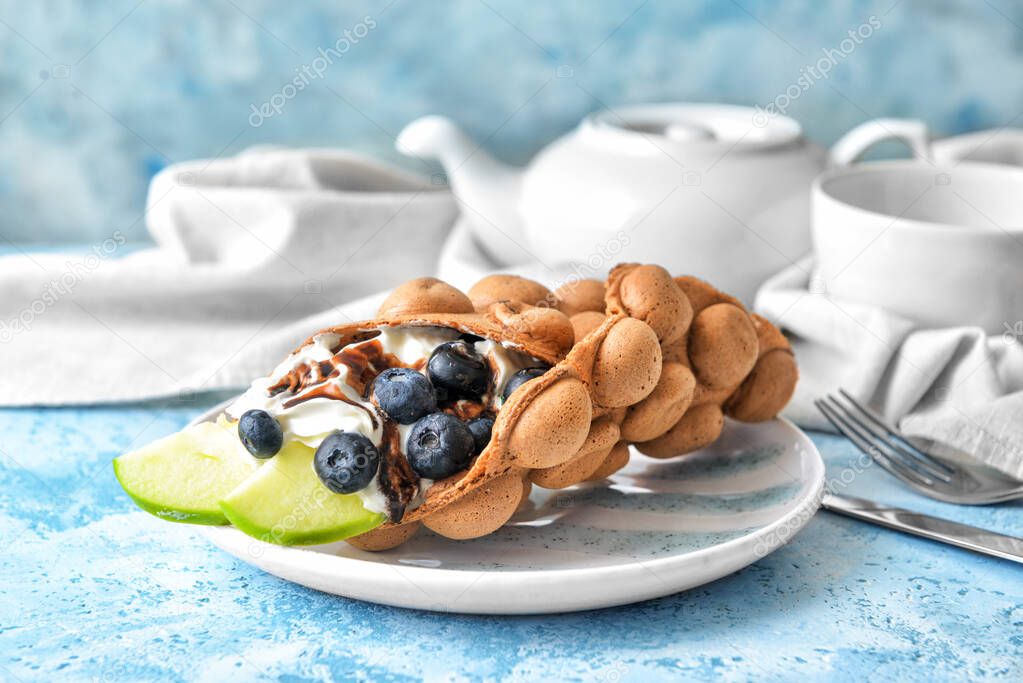 Placa con delicioso gofre de burbuja dulce en la mesa 2024