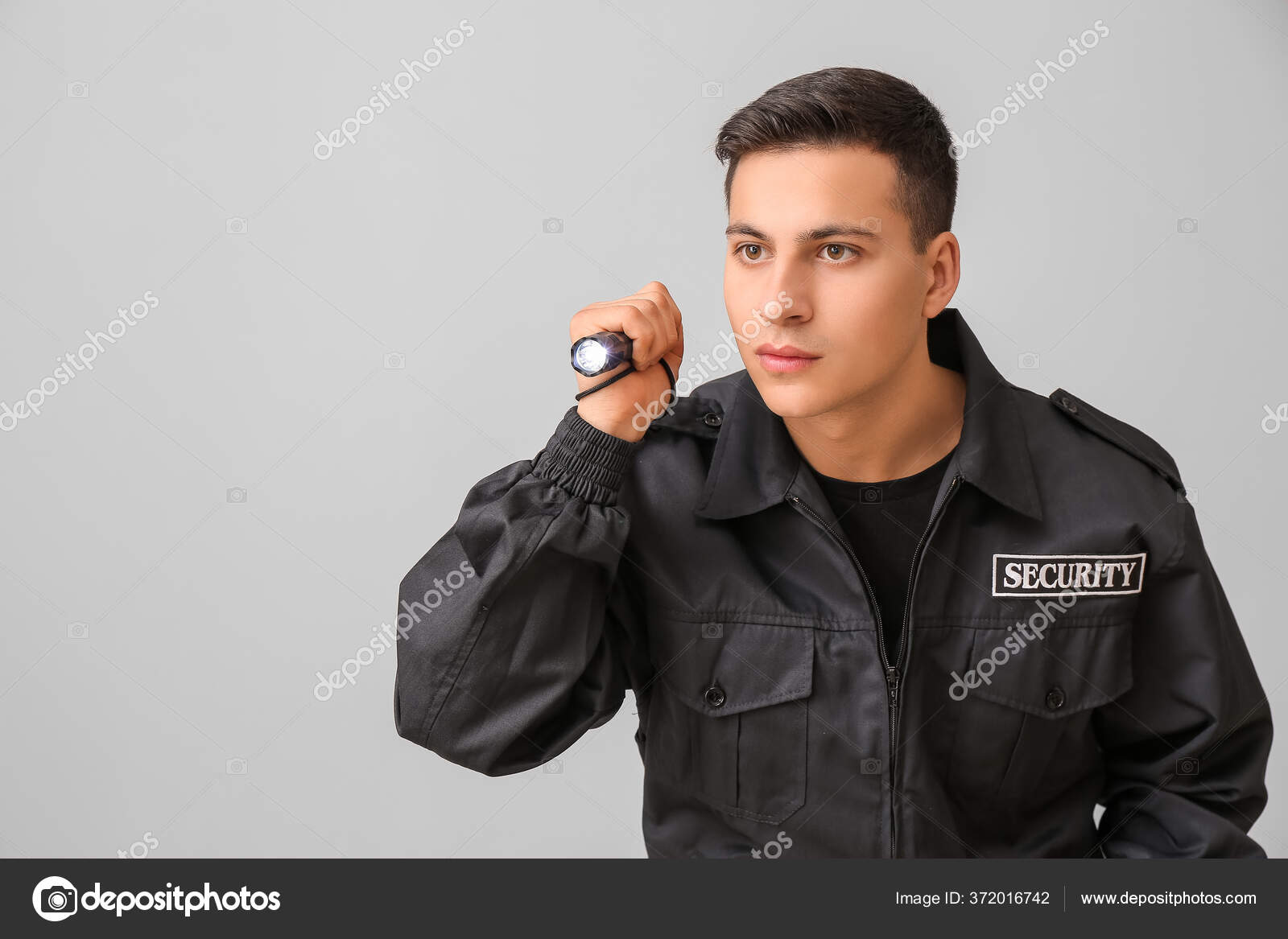 Fotos de Guardia Seguridad Masculino Con Linterna Sobre Fondo Gris ...