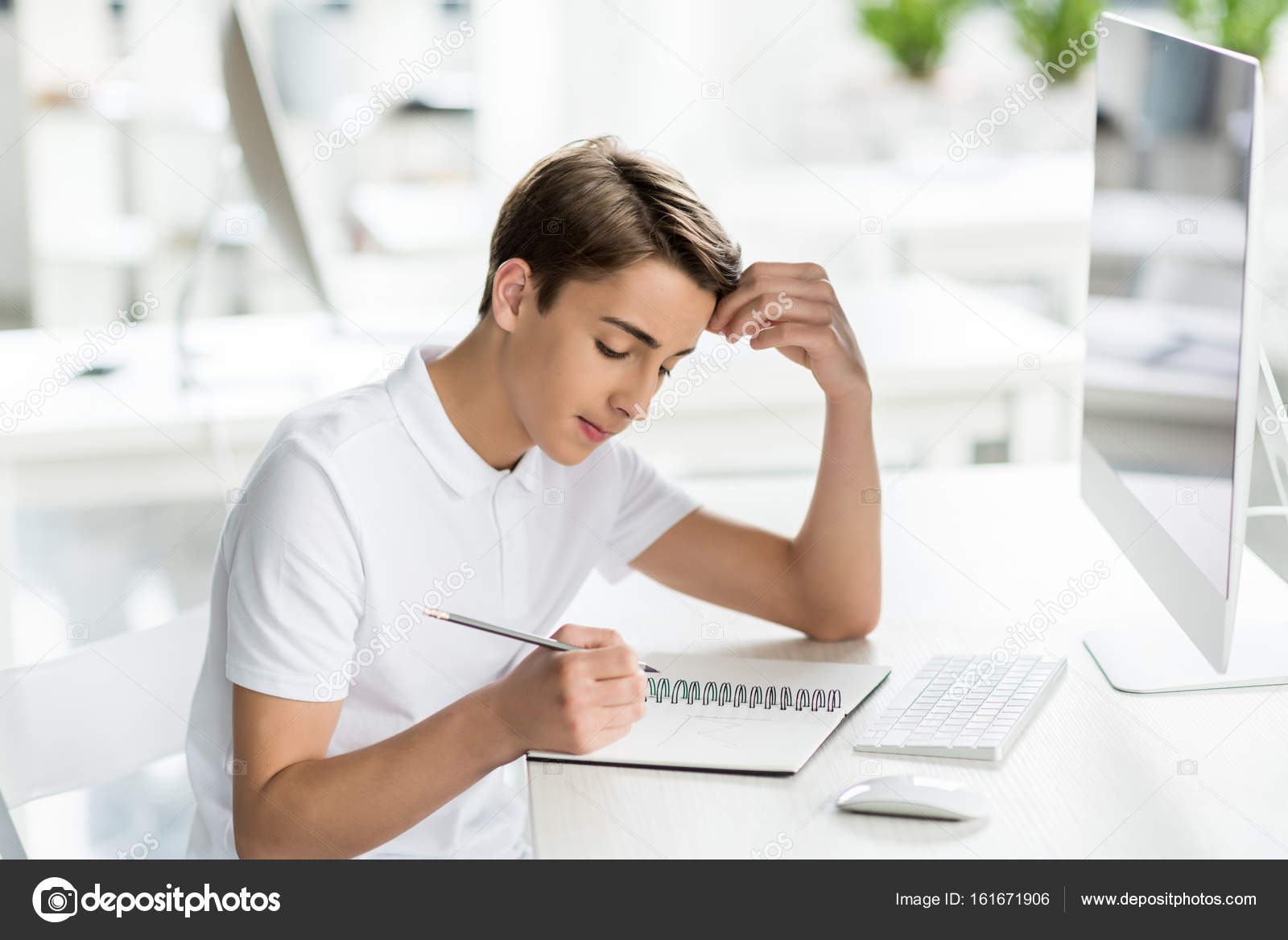 Focused student doing task Stock Photo by ©IgorTishenko 161671906