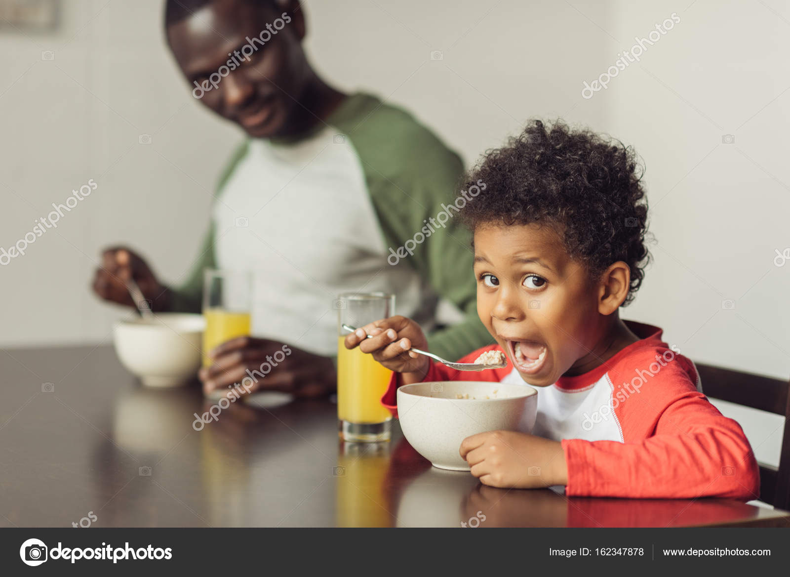 Father and son eating breakfast — Stock Photo © IgorTishenko #162347878