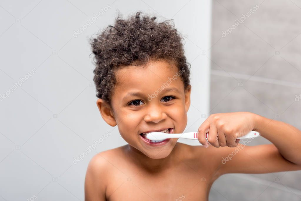 Afro kid brushing teeth — Stock Photo © IgorTishenko #162349694