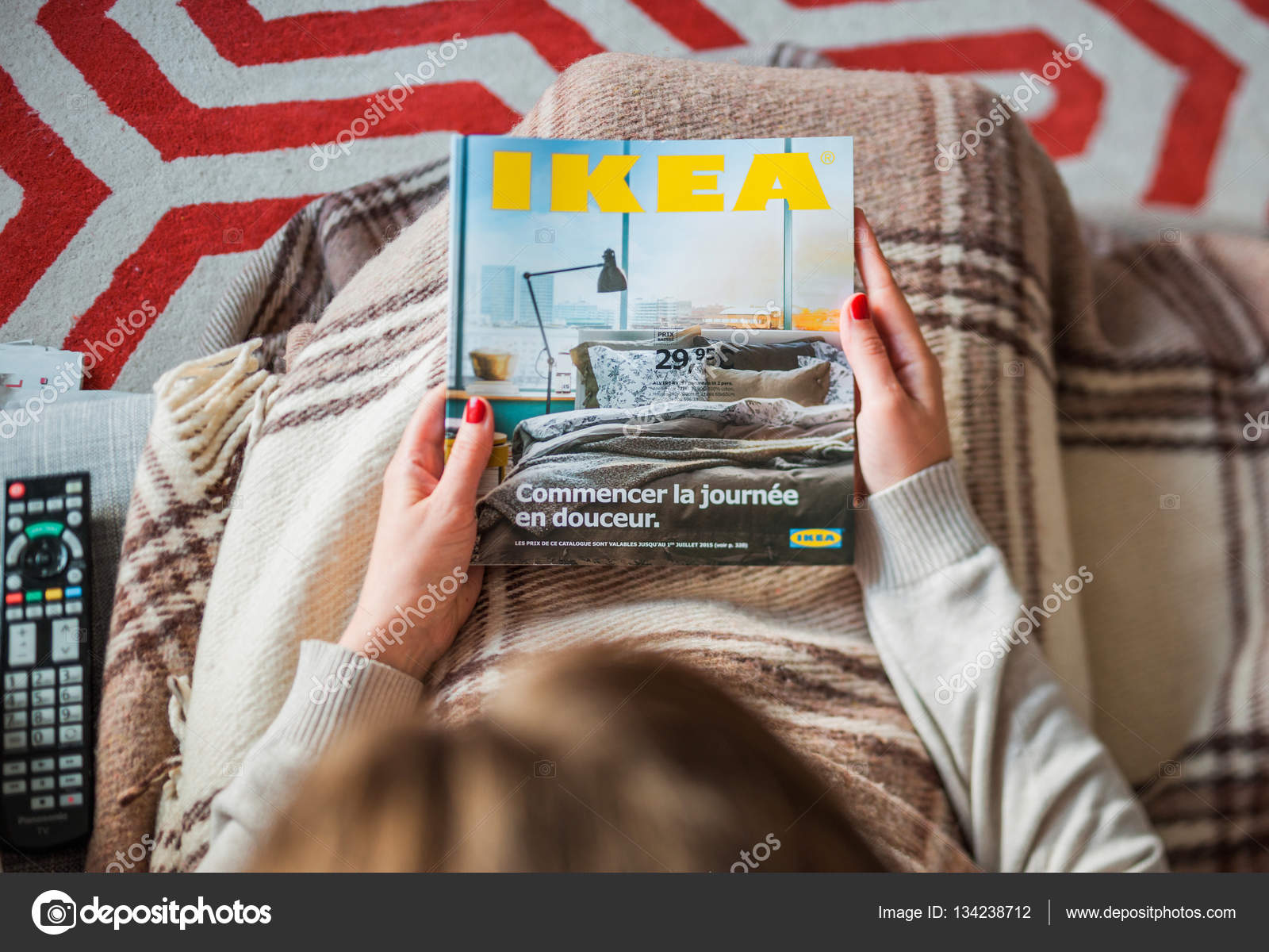 Woman reading IKEA catalog cover before furnishing house — Stock ...