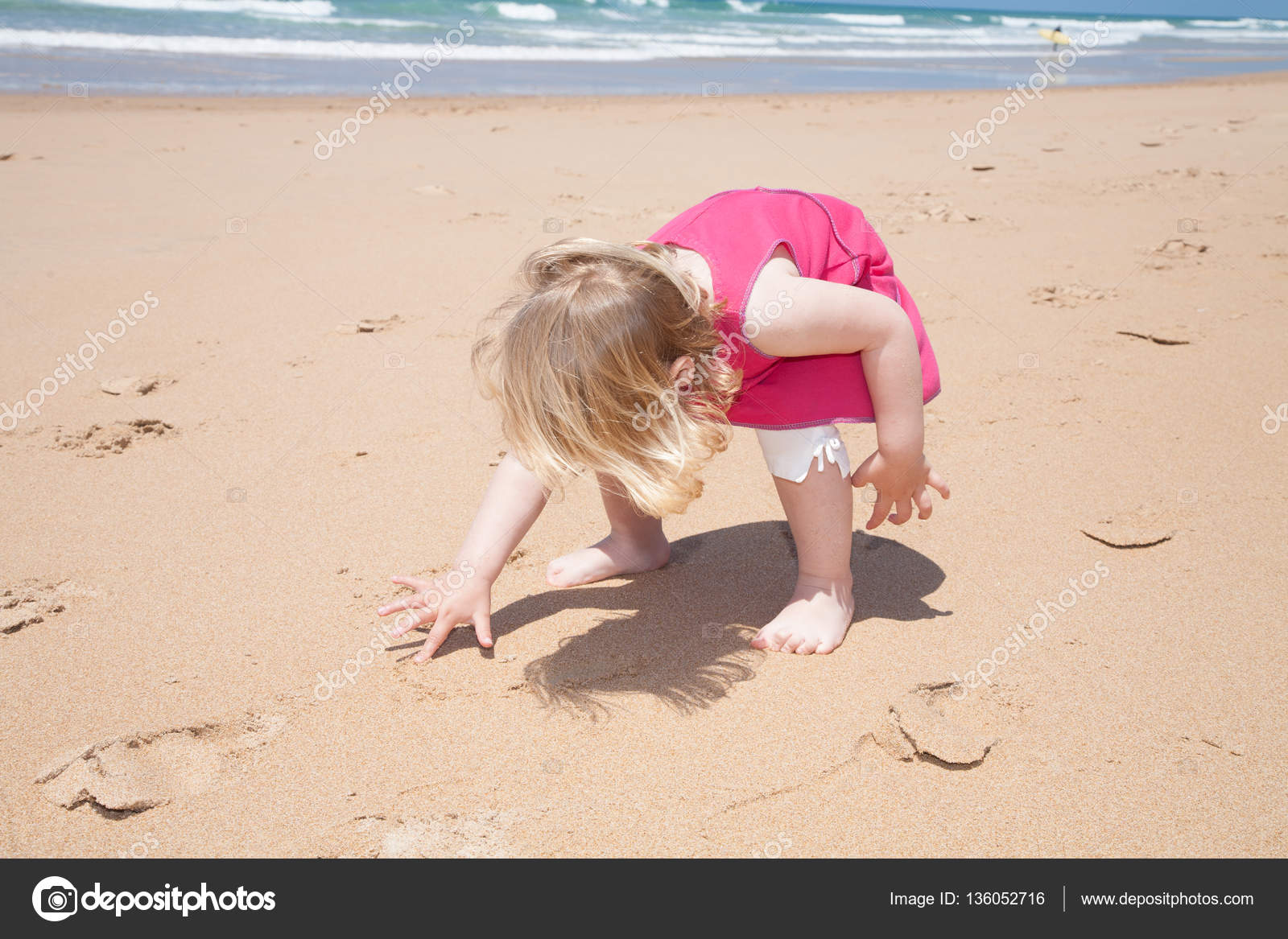 Niña Agacharse Y Escribir Con El Dedo En La Playa De Arena Fotografía