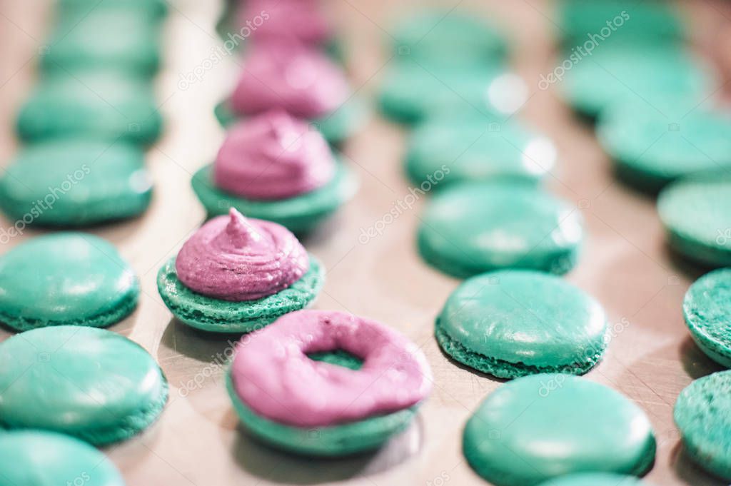conchas de macarrones en una bandeja. Proceso de hacer macaron, postre ...