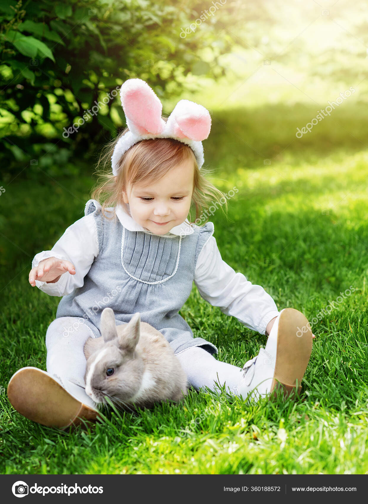 Children play with real rabbit. Laughing child at Easter egg hunt with ...