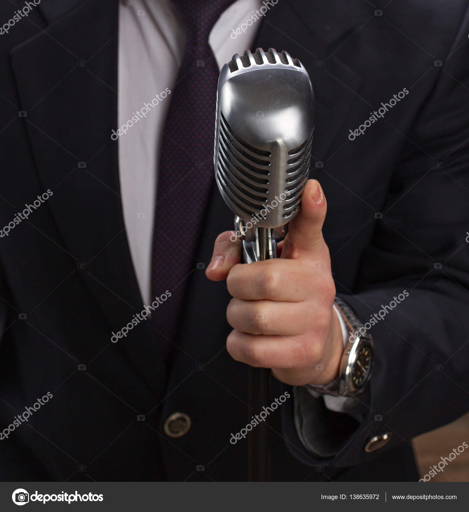 Man holding a retro microphone over black background Stock Photo by ...