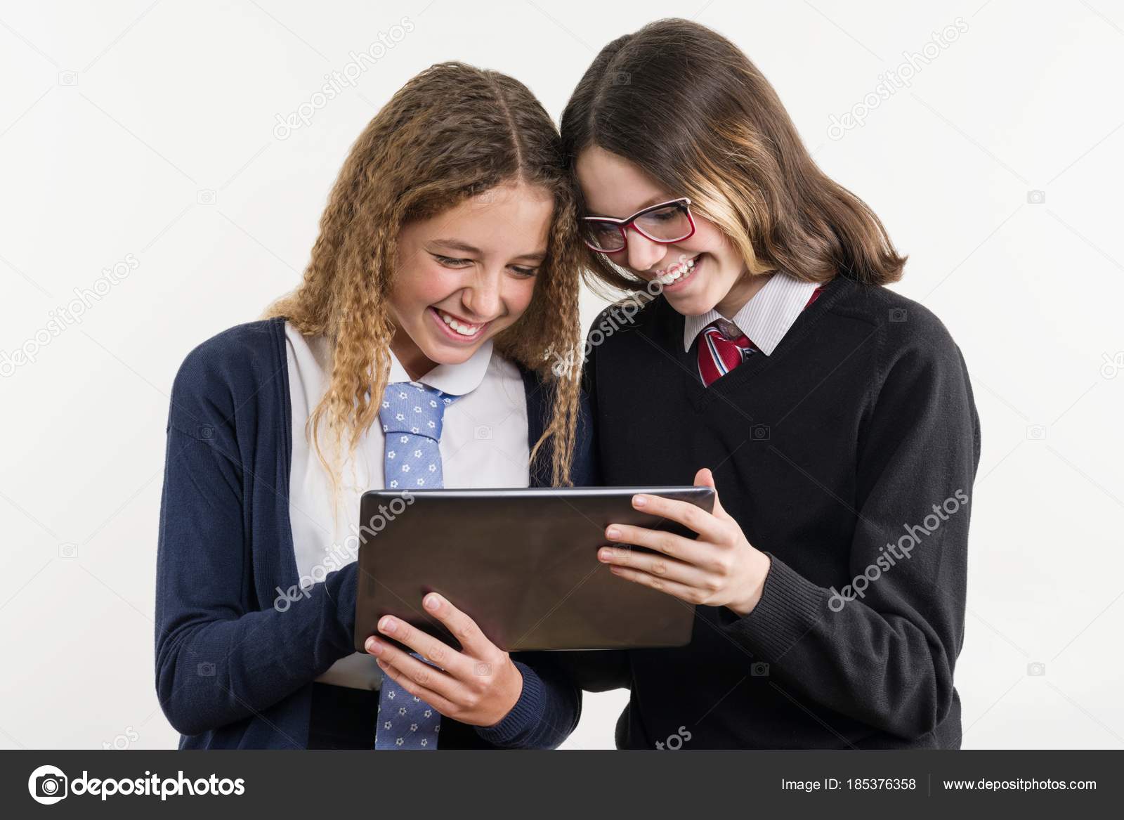 Happy high school friends are teenage girls, look at the tablet and ...