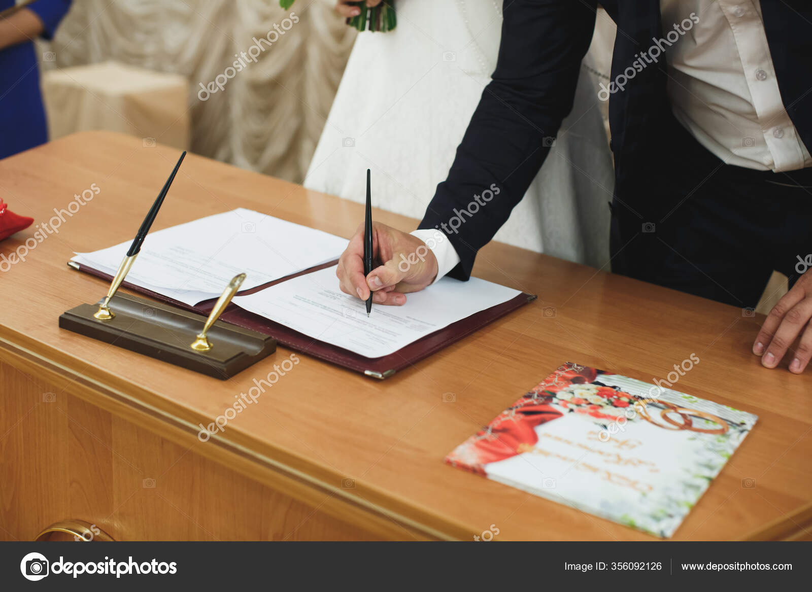 Bride and groom signing marriage wedding certificate at registry ...