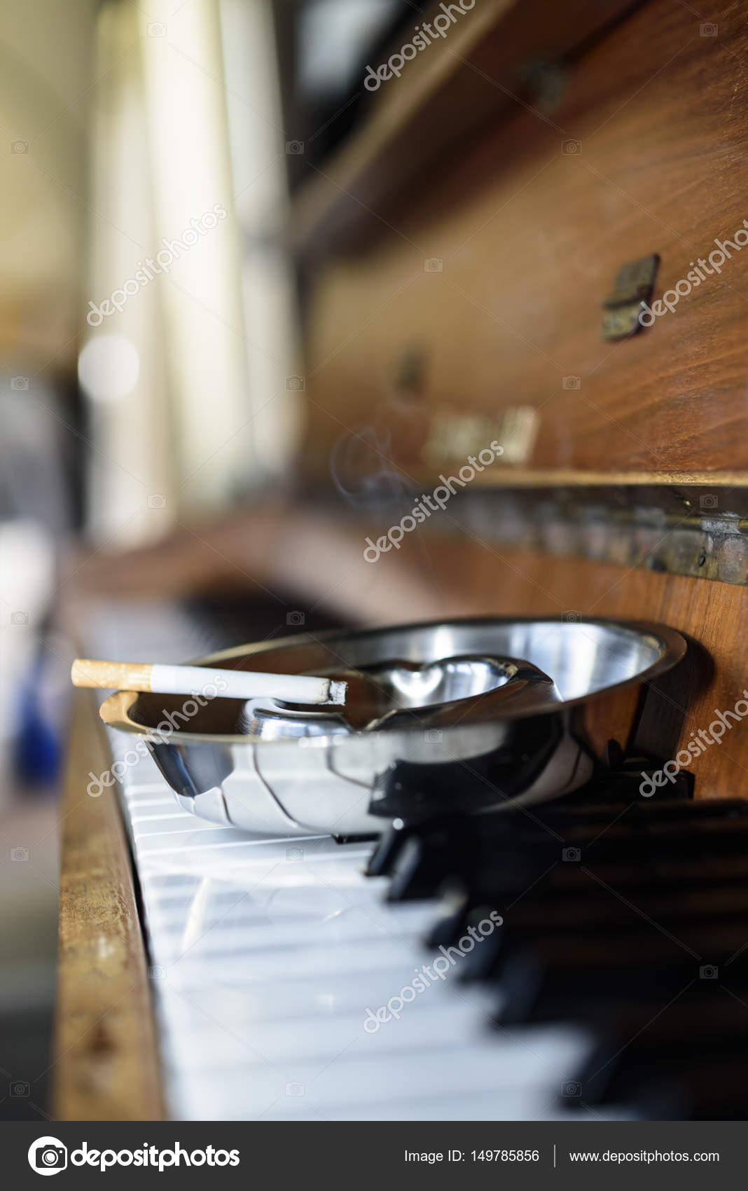 Ashtray on the piano keyboard , cigarette, blurred background Stock ...