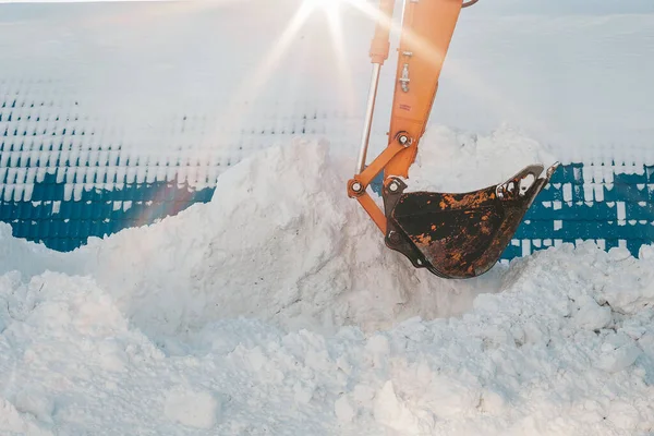 Snow removal after snowfall and blizzards. Excavator loads snow into a ...