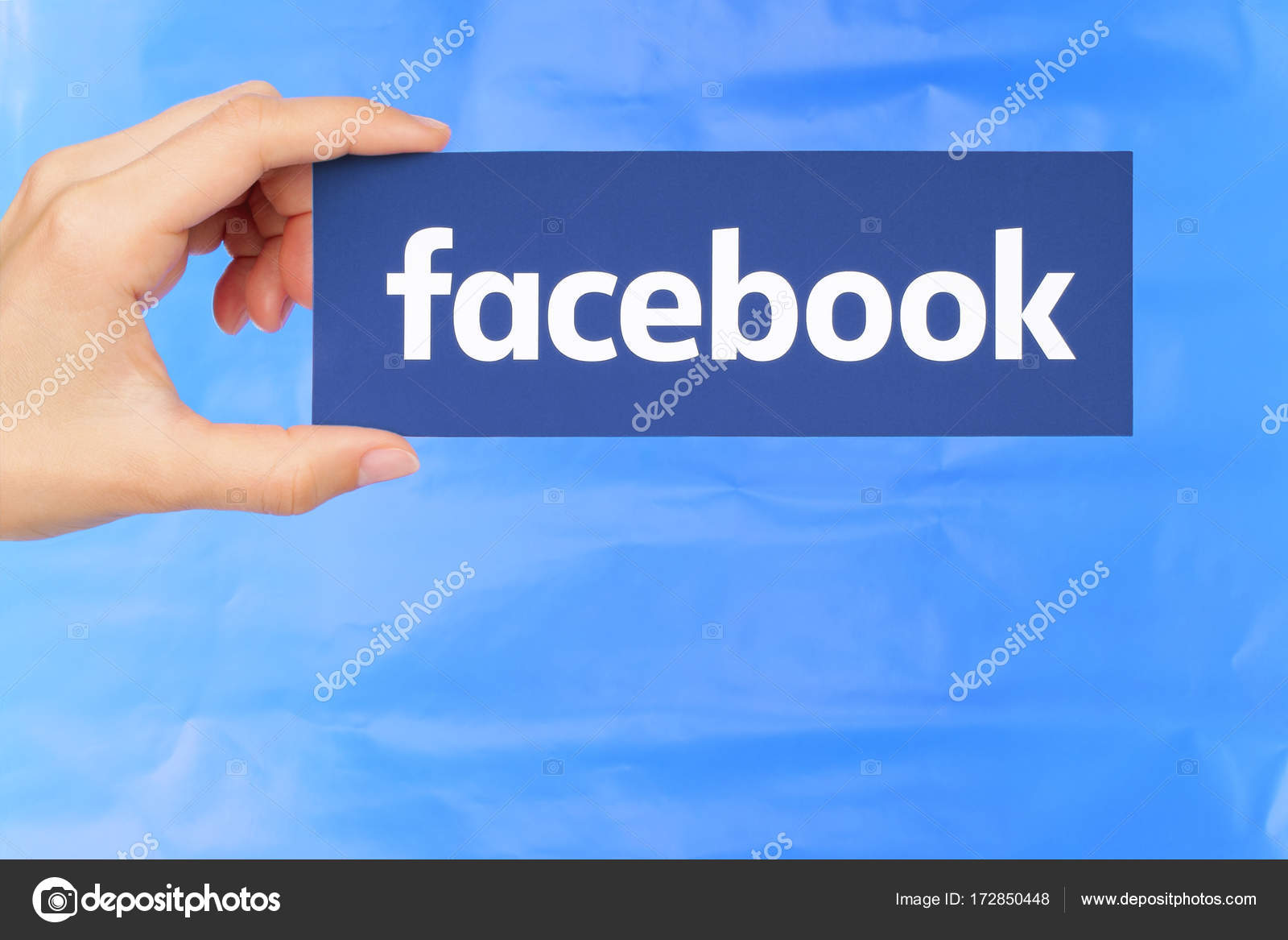 Ruka drží loga Facebooku na modré papírové pozadí - Stock redakční Foto ...