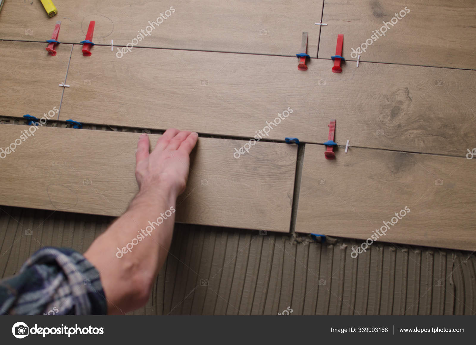 Laying tile on the floor, ceramic tile laying, pressing down and ...