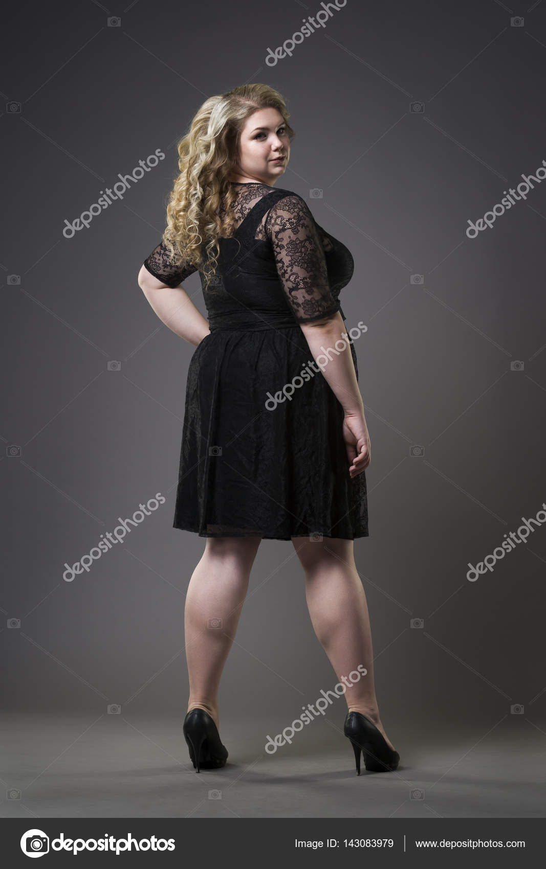 Young beautiful plus size model in black dres, xxl woman on gray studio ...