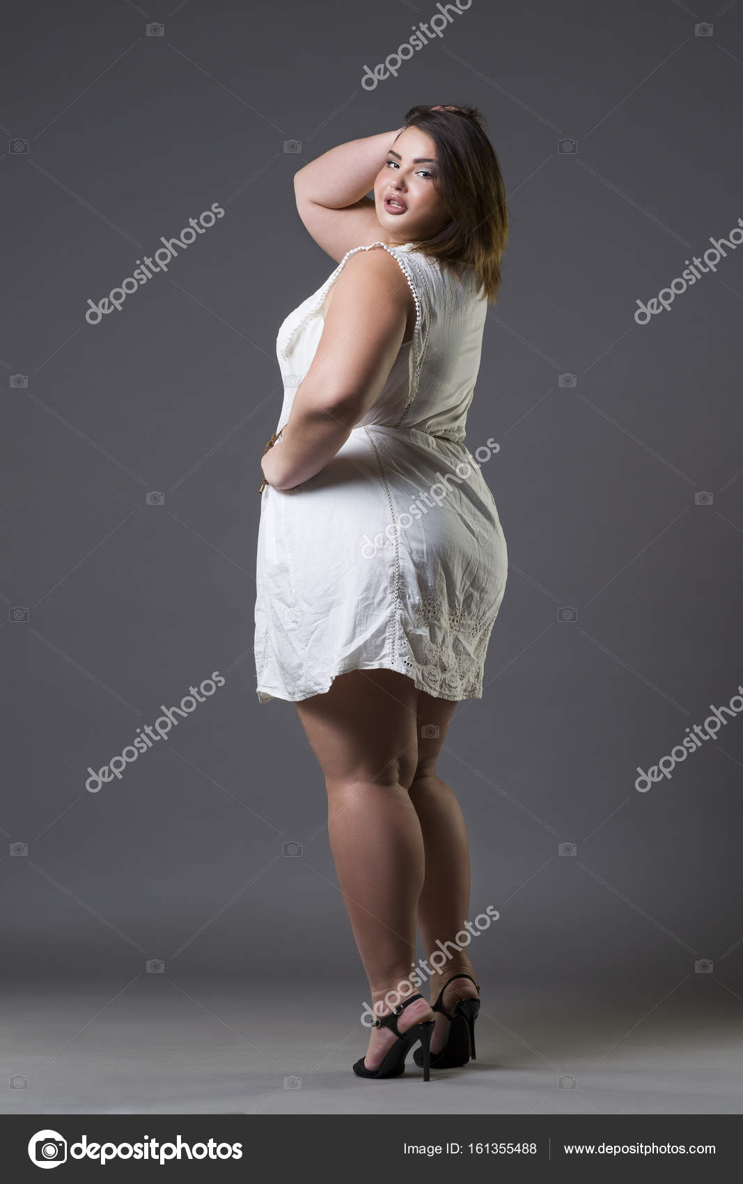Happy plus size fashion model in casual clothes, fat woman on gray ...