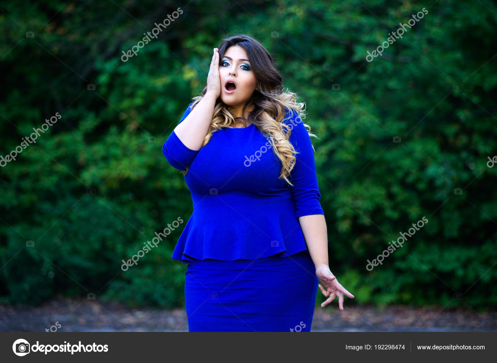 Surprised plus size fashion model in blue dress outdoors, beauty woman ...