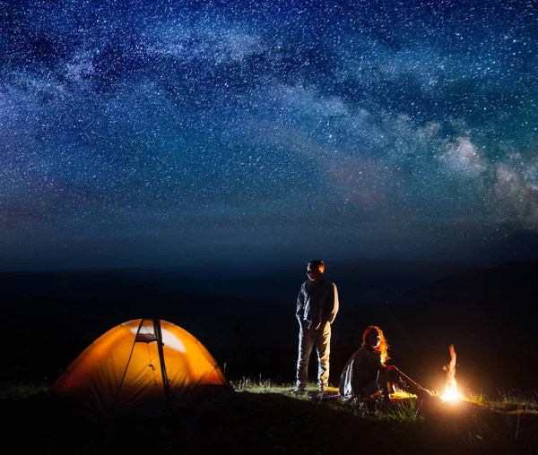 Romantic pair tourists in his camp at night near campfire Stock Photo ...