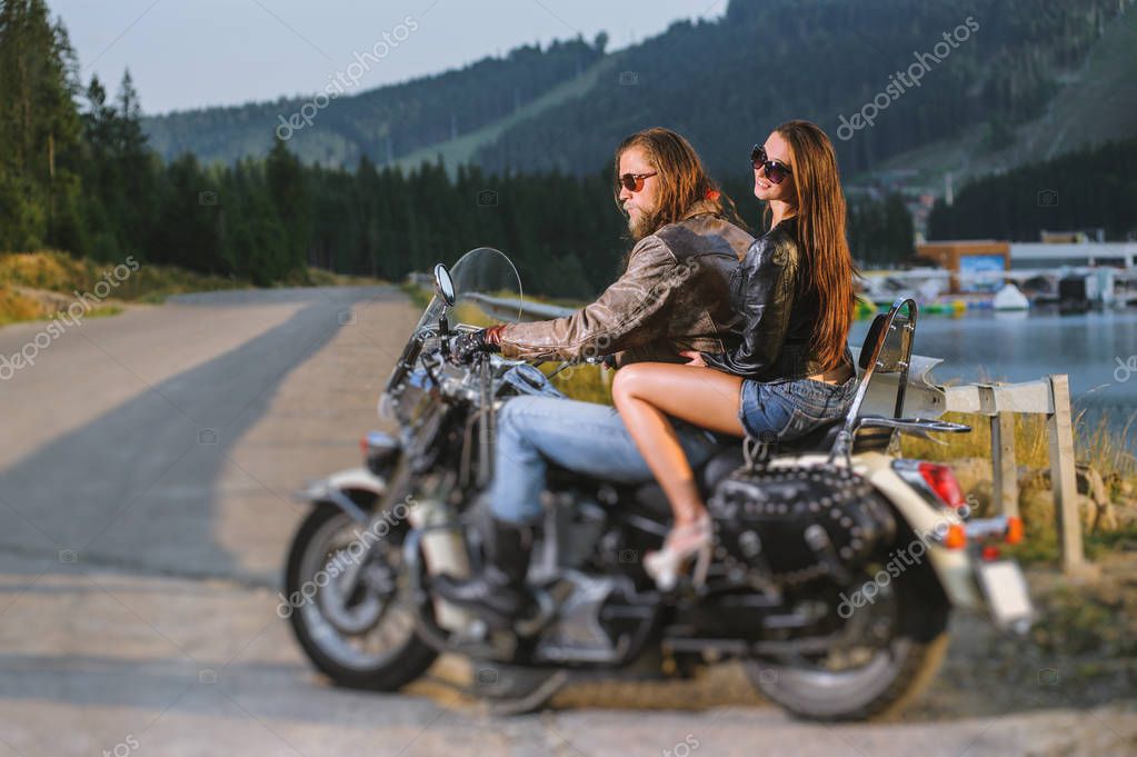 Couple riders sitting together on shiny custom made cruiser motorcycle ...
