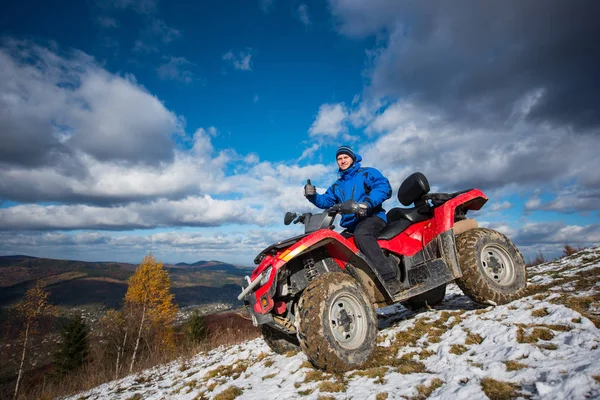 man on atv off-road vehicle resting up in the mountains and showing ...