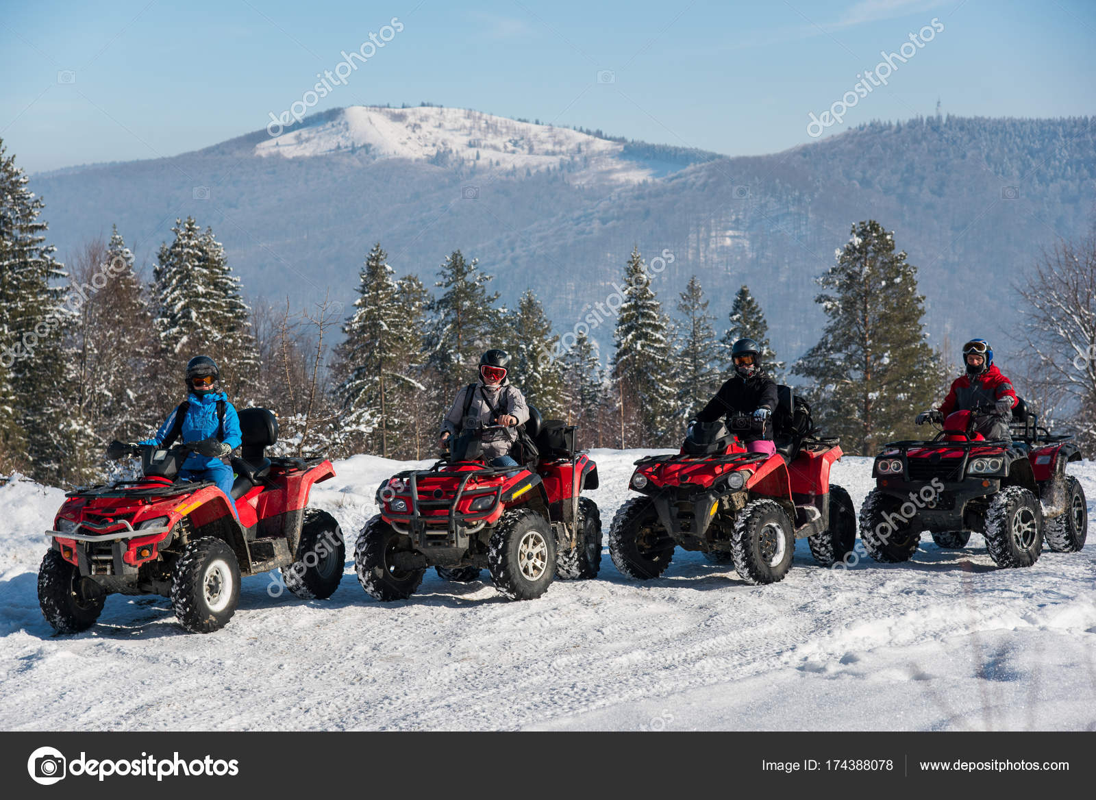 Group of people driving quad bikes on snow at top of the mountain in ...