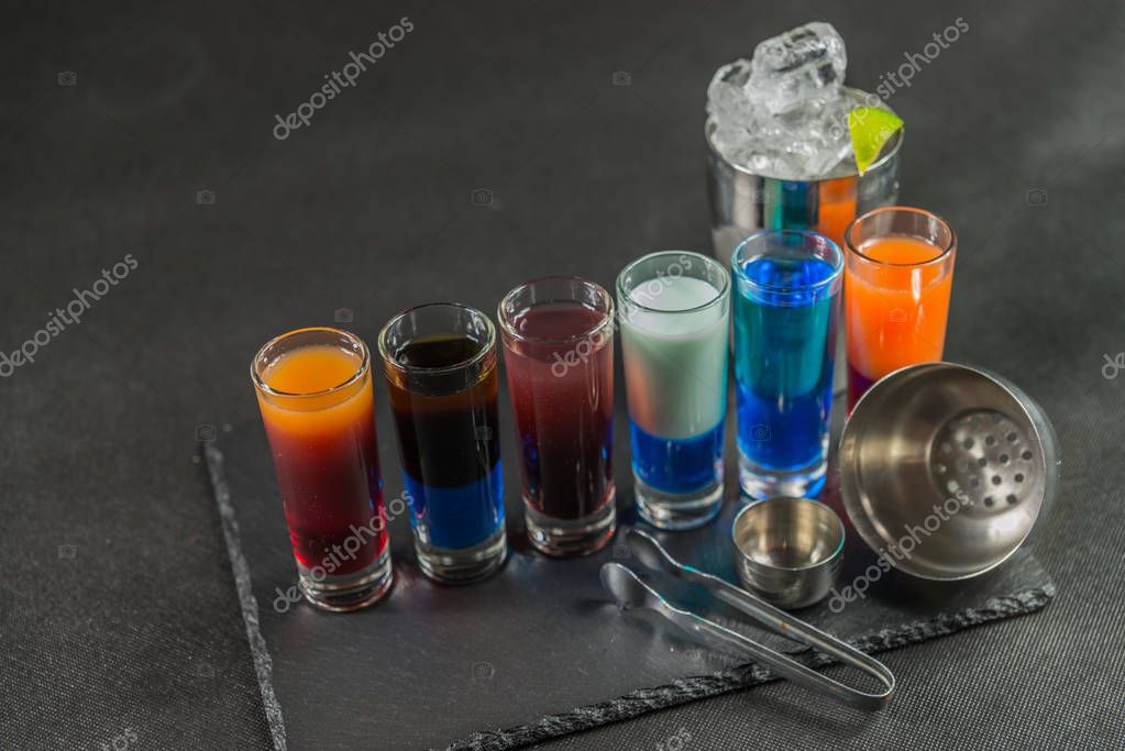 Seis tragos de diferentes colores, alineados en un pla de piedra negra 2022