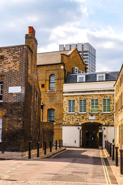 Typical old English buildings, low brick buildings across a narr ...