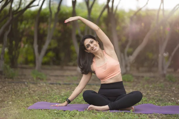 Beautiful Indian woman sitting crossed legged yoga pose — Stock Photo ...
