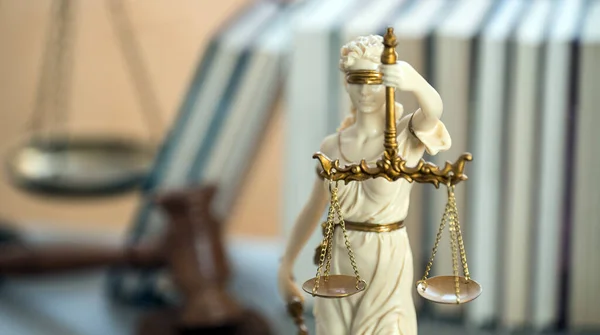 Statue of Justice with libra and books on background, court and law ...