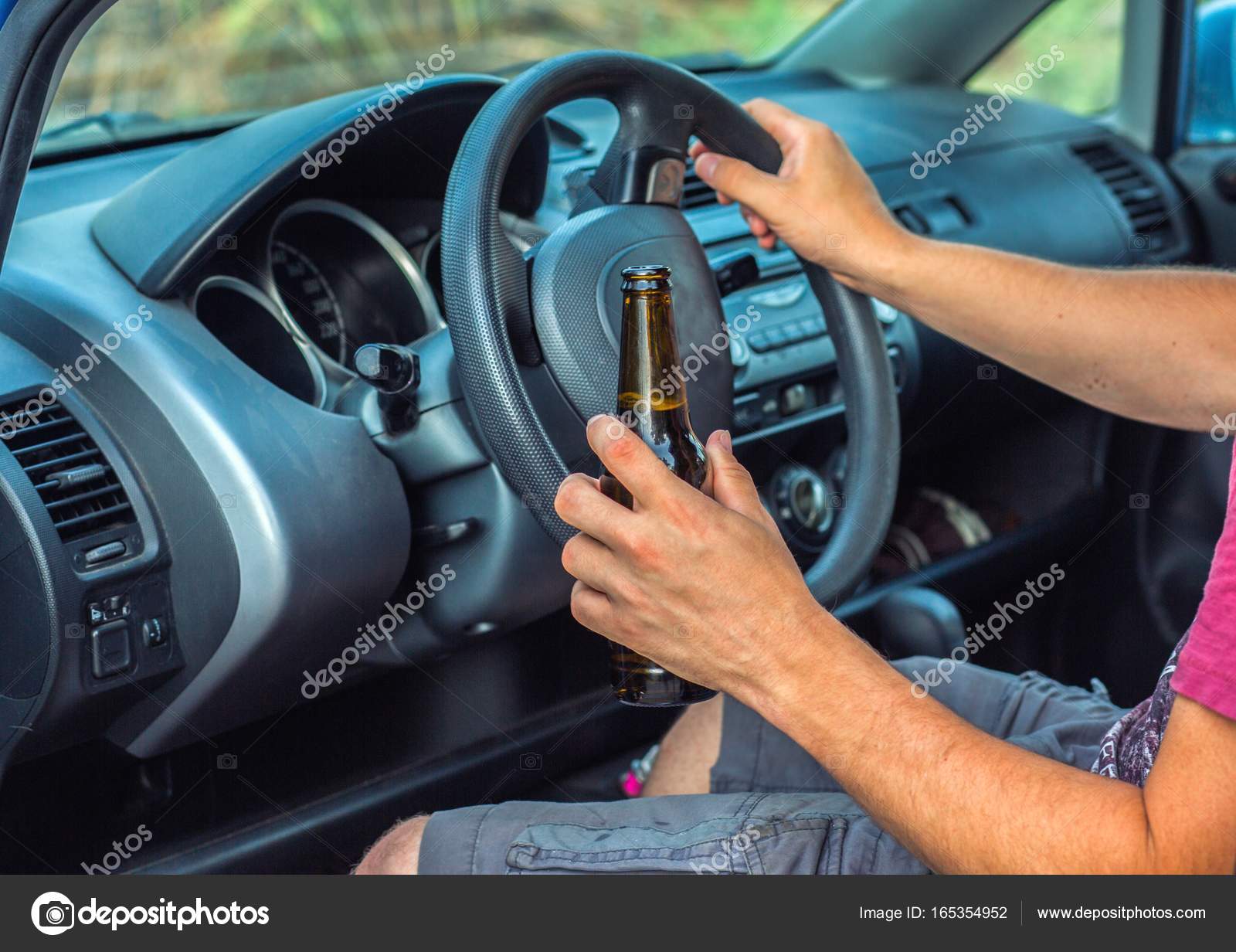 Man drinking alcohol while driving a car — Stock Photo © Layue #165354952