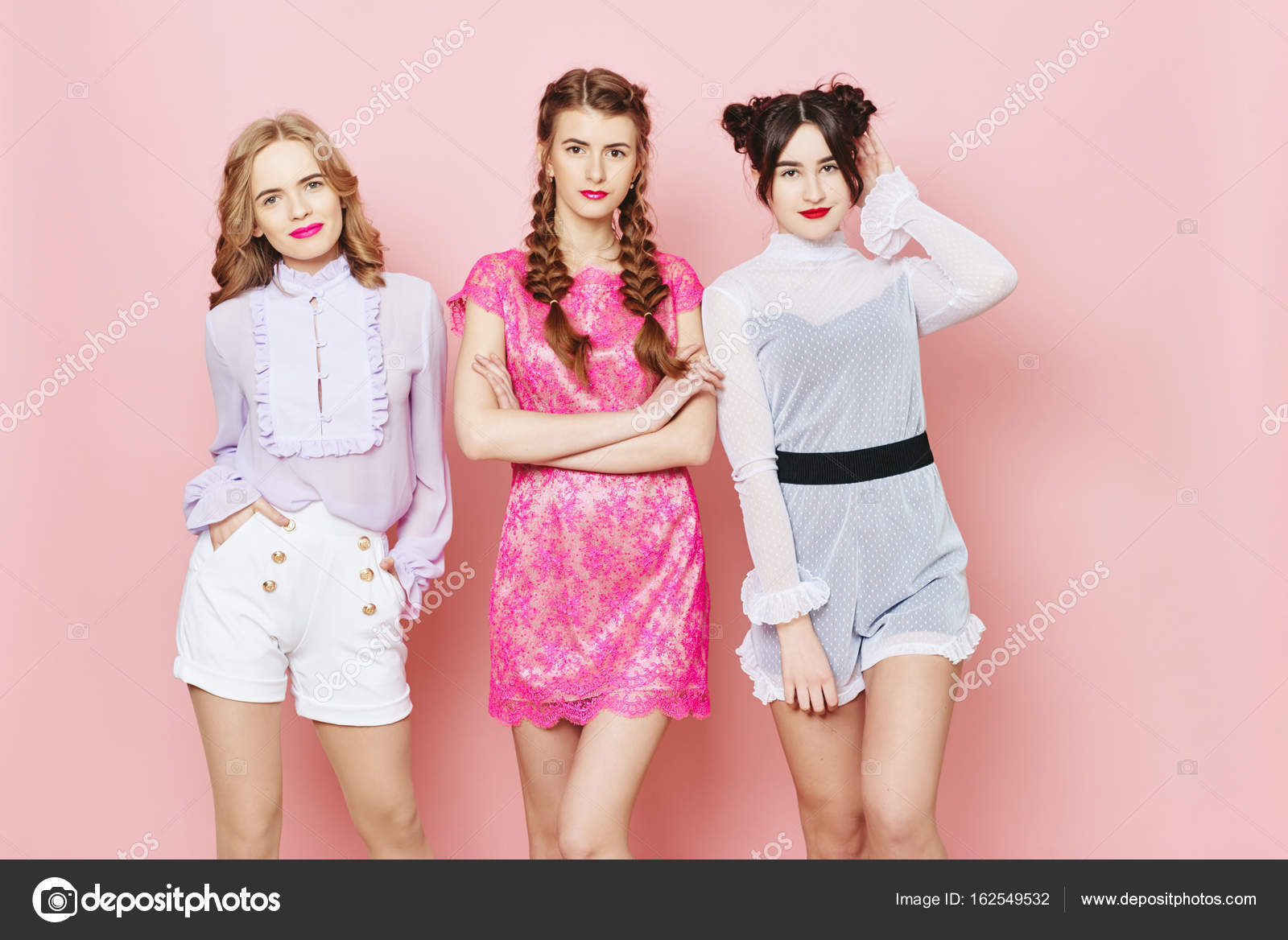 Fashion photo of three young girl posing over pink background in studio ...