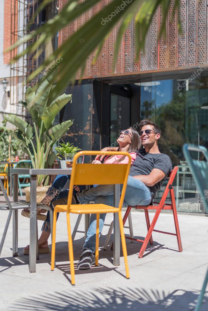 Feliz pareja joven sentado relajado en una terraza restaurante 2023