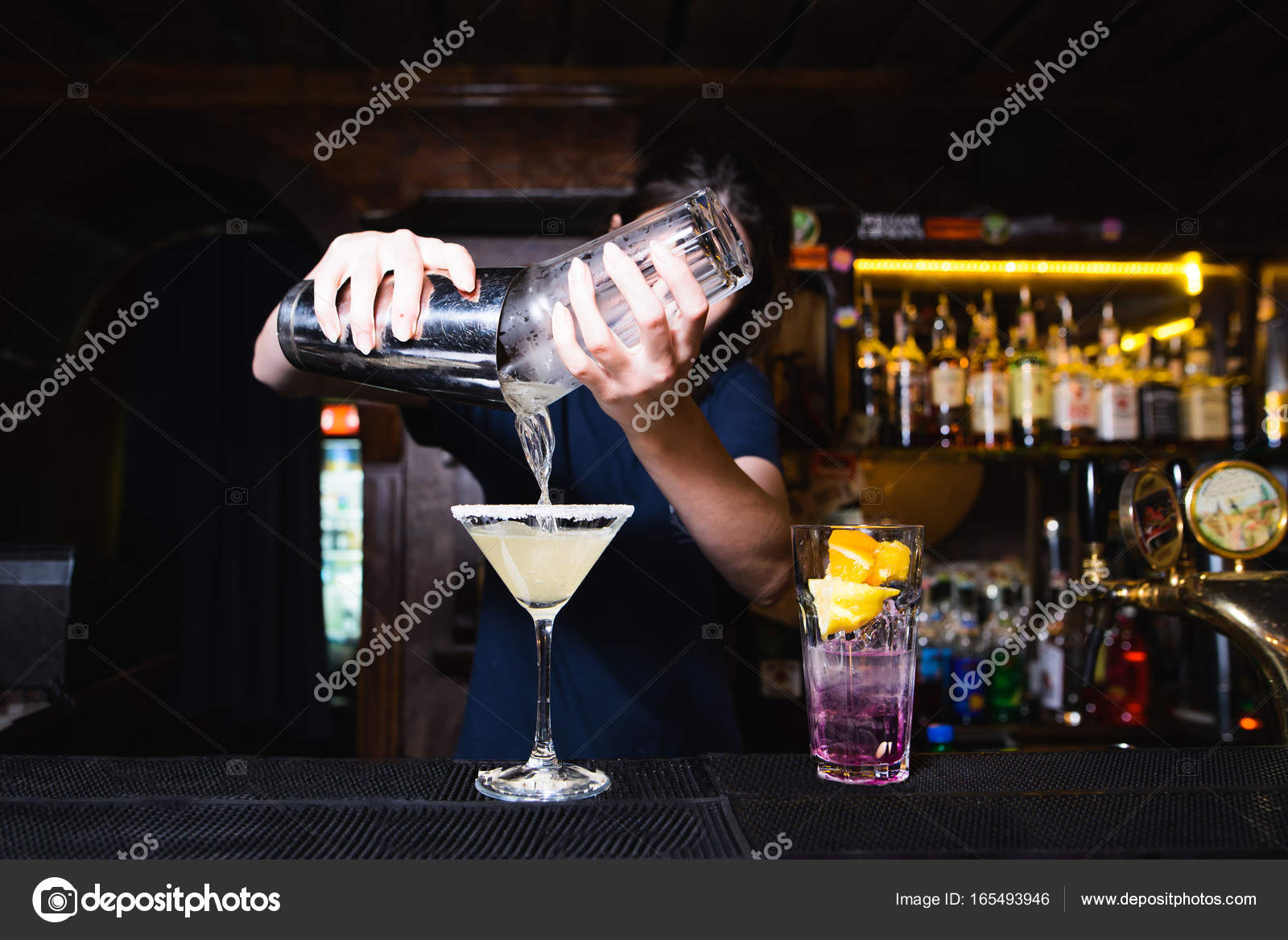 Bartender creates beautiful alcoholic cocktails at the bar. The barman ...