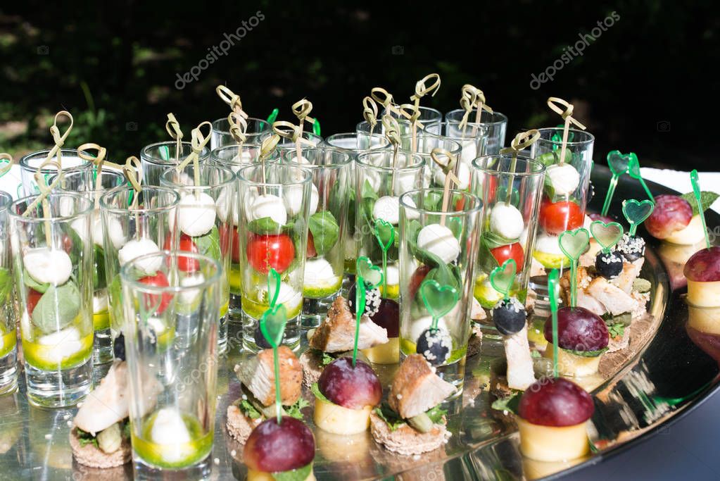 Gafas de vidrio. Las copas están llenas de bocadillos: tomate cherry ...