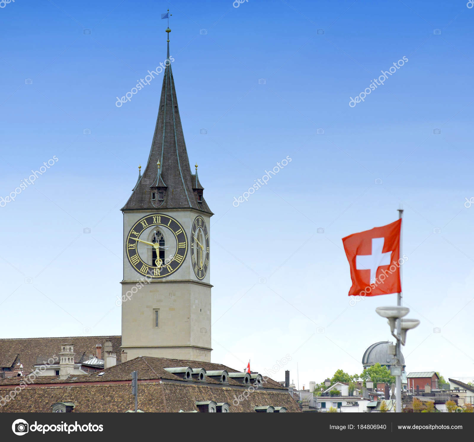 Clock tower of the St. Peter Church and Swiss Flag on the facade ...
