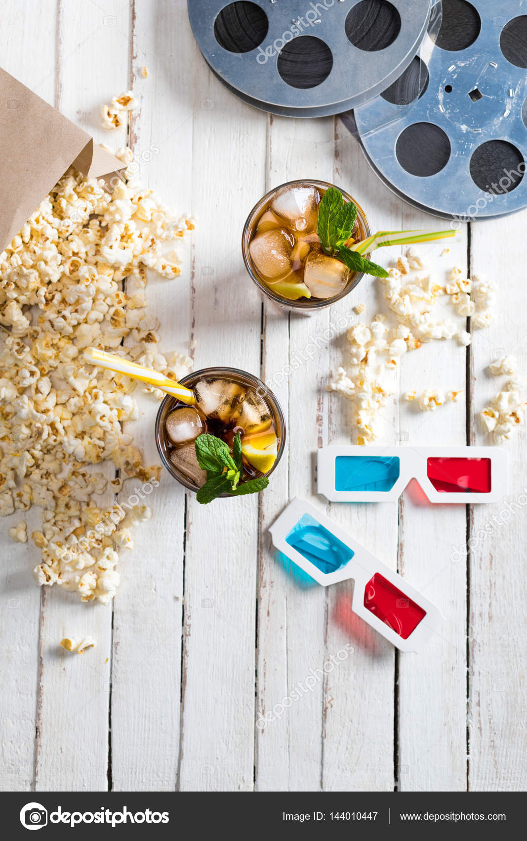 Popcorn with iced tea and film reels — Stock Photo © K.Klimenko #144010447