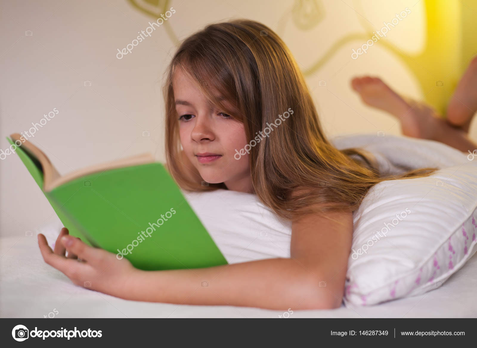 Jeune fille couchée sur le ventre au lit - lecture d'un livre, peu ...