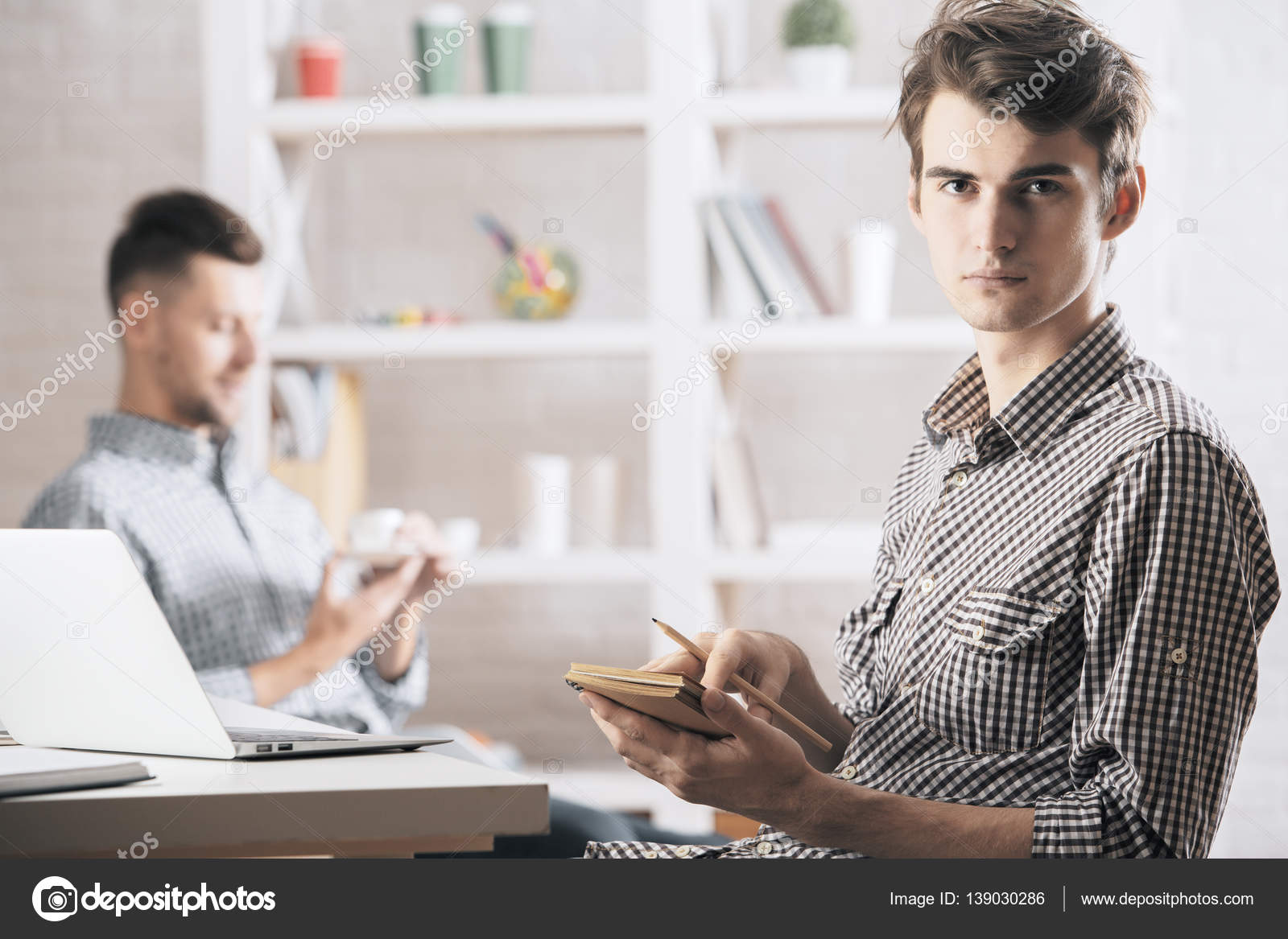 Handsome man writing in notepad Stock Photo by ©peshkova 139030286
