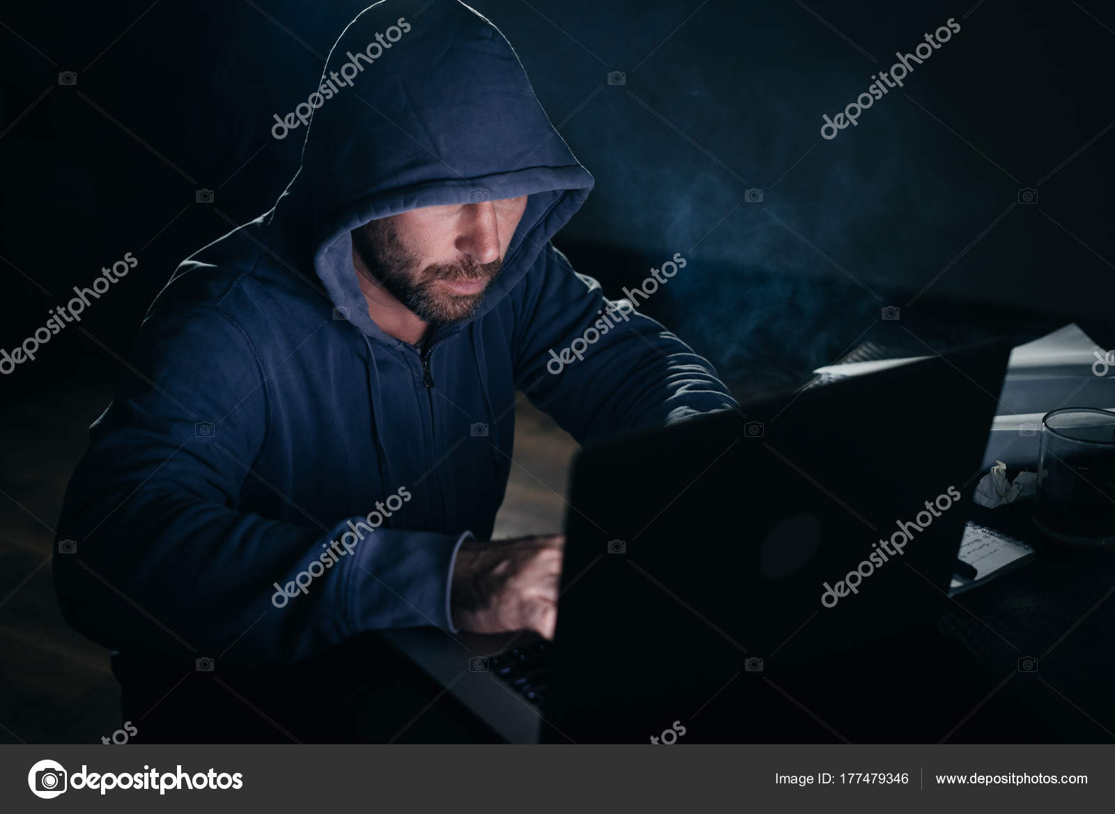 Young mysterious dangerous man hiding his face, doing something illegal ...