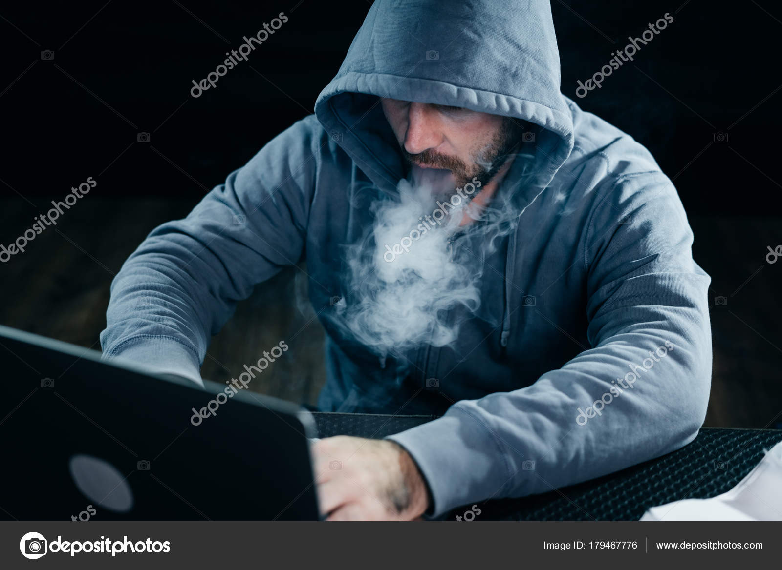 Mysterious bearded man hacker smoking a hookah in the dark, hacking ...