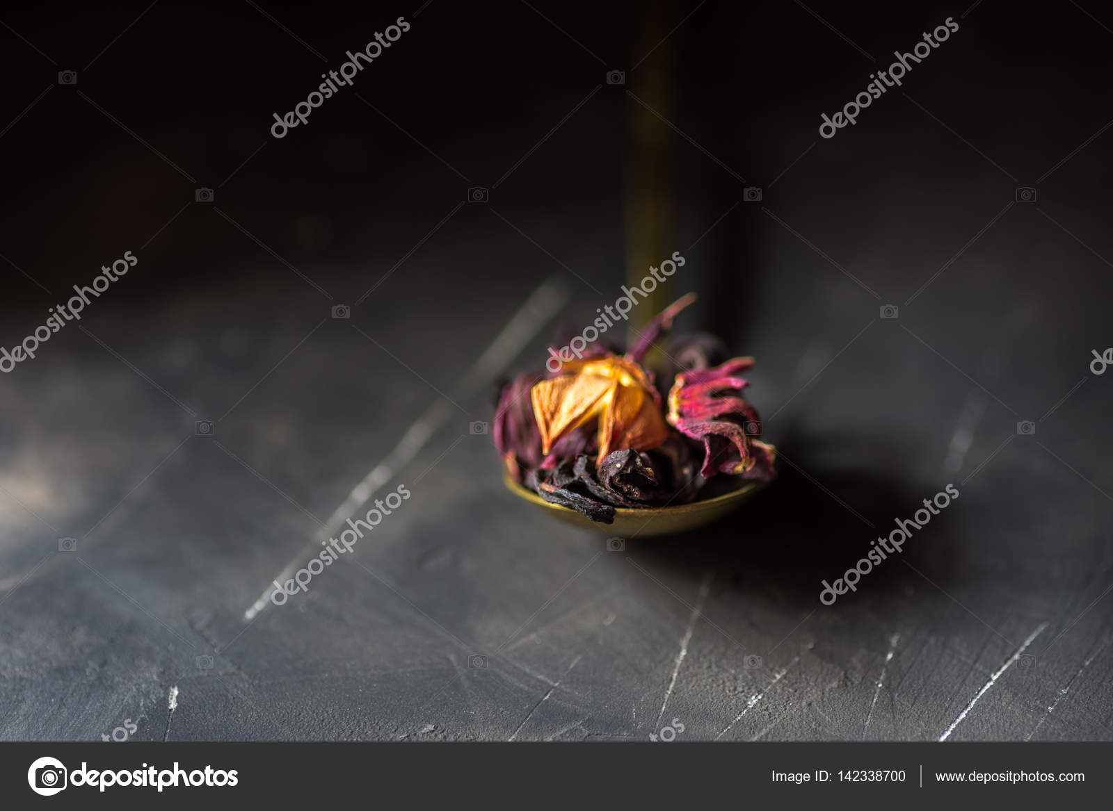 Hibiscus karkade leaves and petals on a vintage copper spoon, black ...