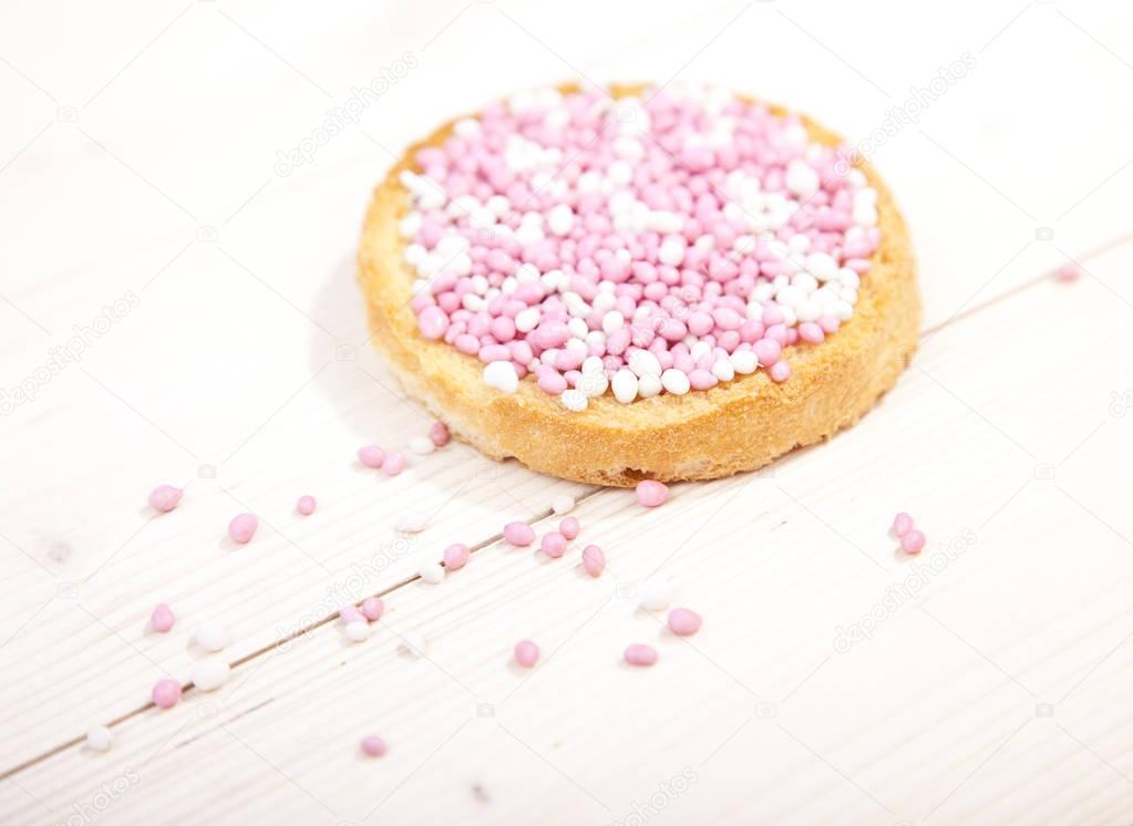 Traditional Dutch birth celebration biscuit with pink muisjes on wooden ...