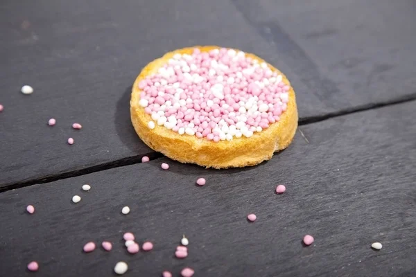 Traditional Dutch birth celebration biscuit with pink muisjes on wooden ...
