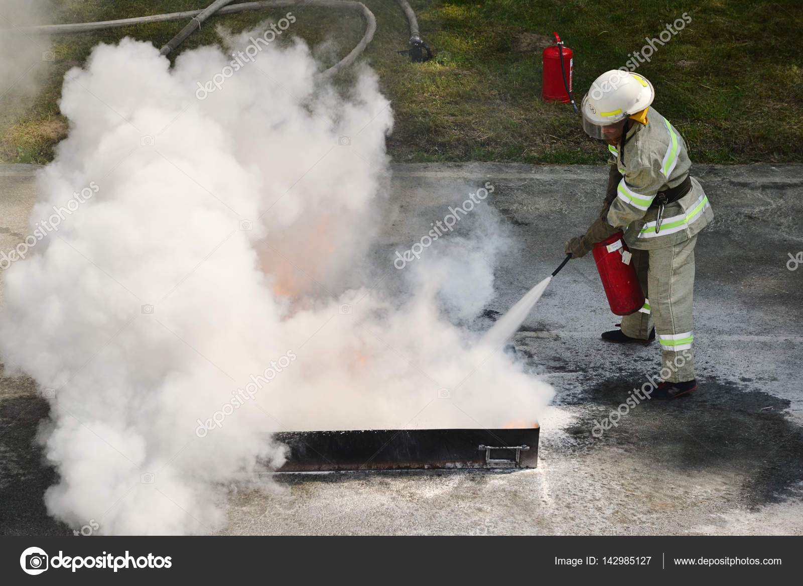 Firefighter using fire extinguisher Stock Photo by ©VAKSMANV101 142985127