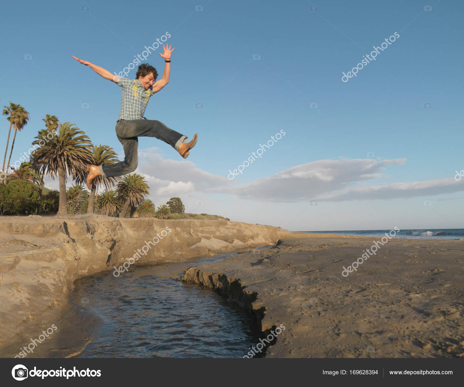 Man Jumping Brook Stock Photo by ©ImageSource 169628394