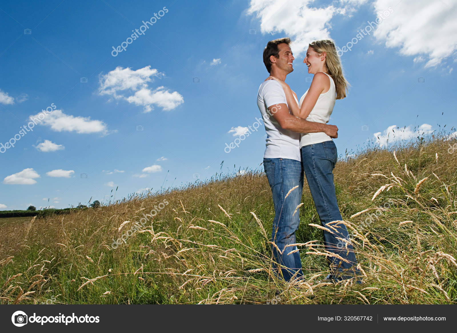 Couple Hugging Field Stock Photo by ©ImageSource 320567742