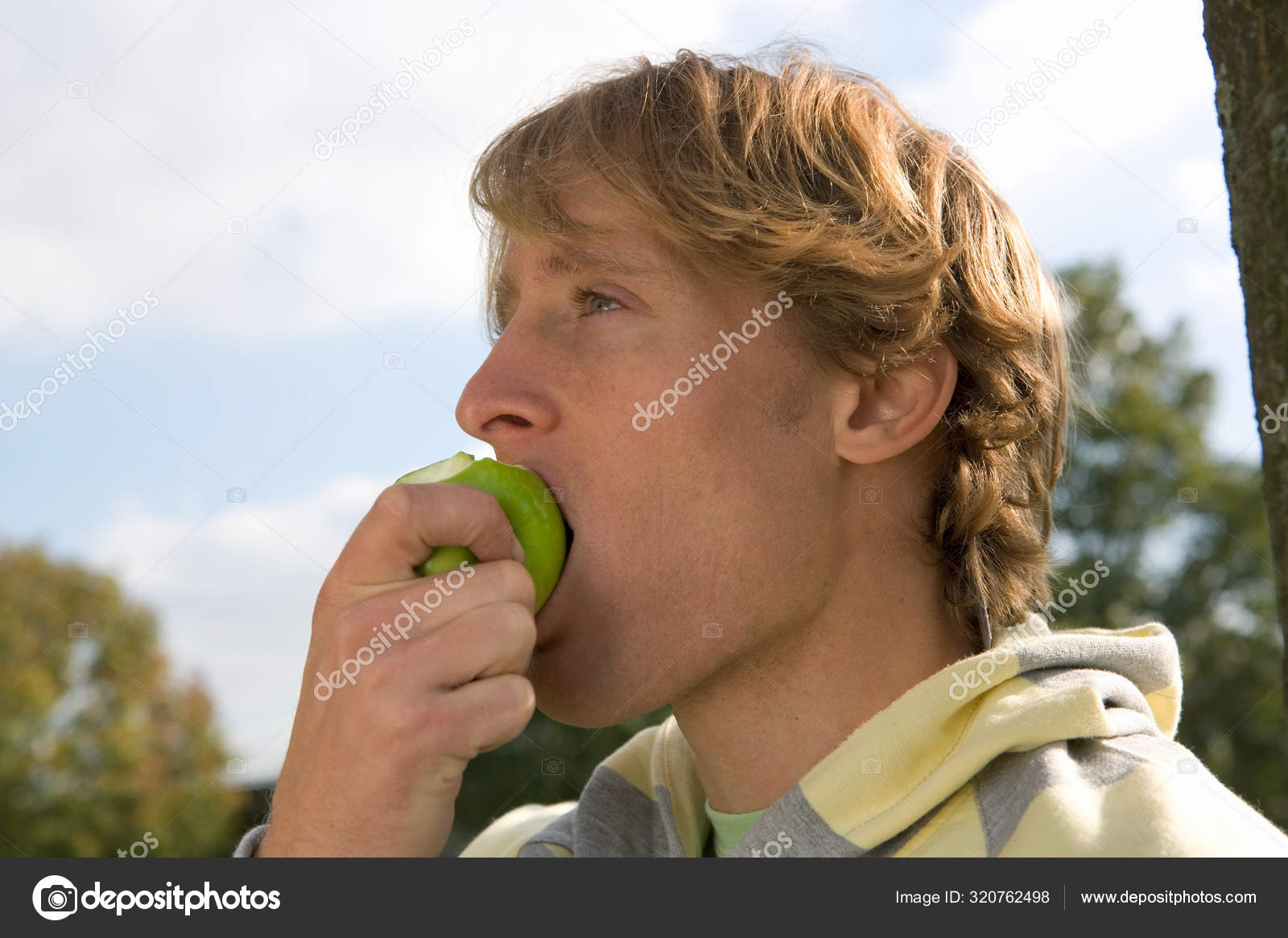 Young Man Eating Apple Stock Photo by ©ImageSource 320762498