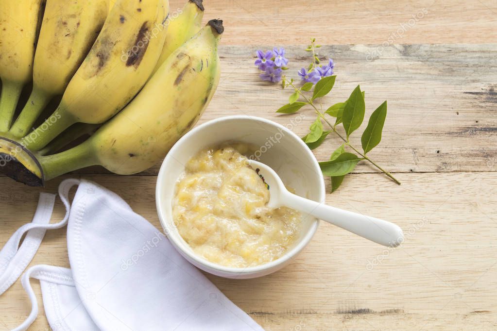 puré de plátano alimentos saludables para el bebé en el fondo de madera 2024