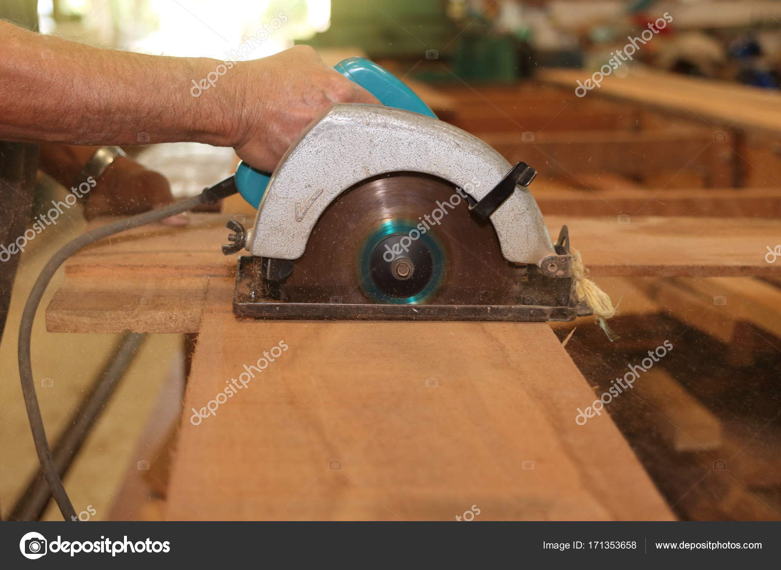 Front view of hands of senior carpenter cutting a piece of wood against ...