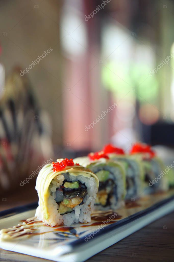 Aguacate sushi maki sobre fondo de madera, comida japonesa 2024
