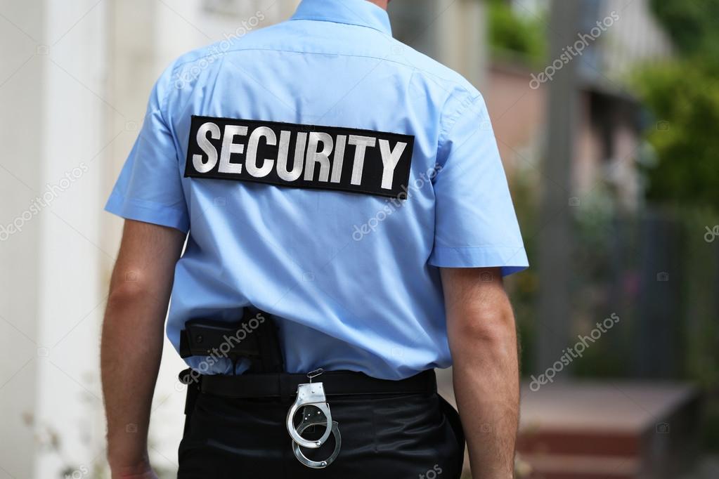 Male security guard standing back outdoors — Stock Photo © belchonock ...