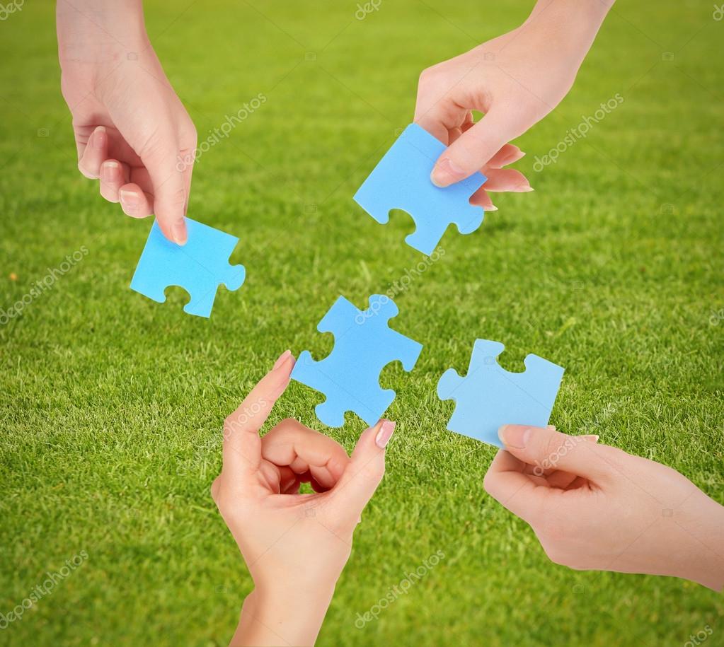 Hands with blue puzzle pieces on green grass background. Stock Photo by ...